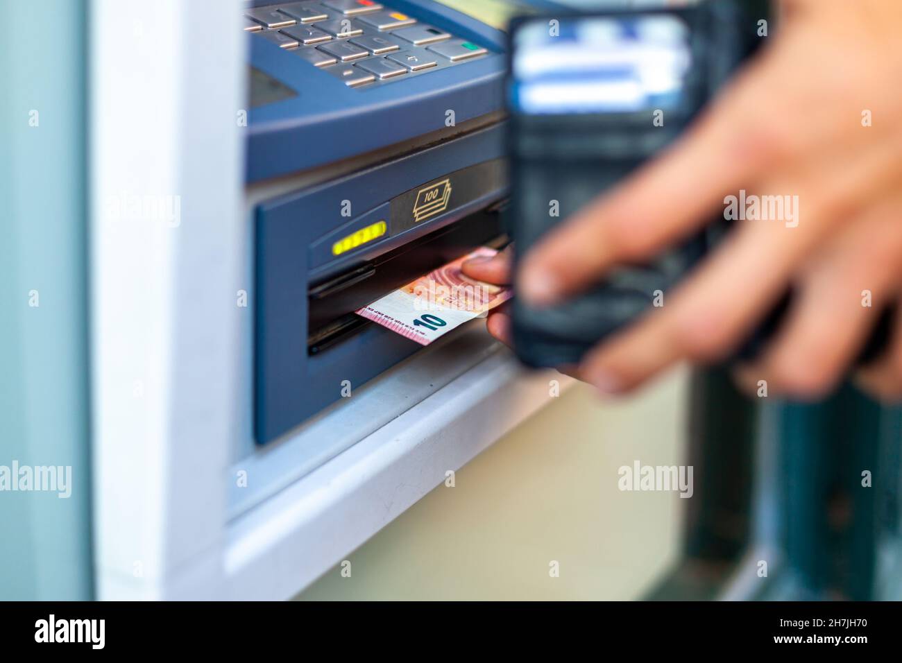 withdraw cash from an ATM on a city street Stock Photo - Alamy