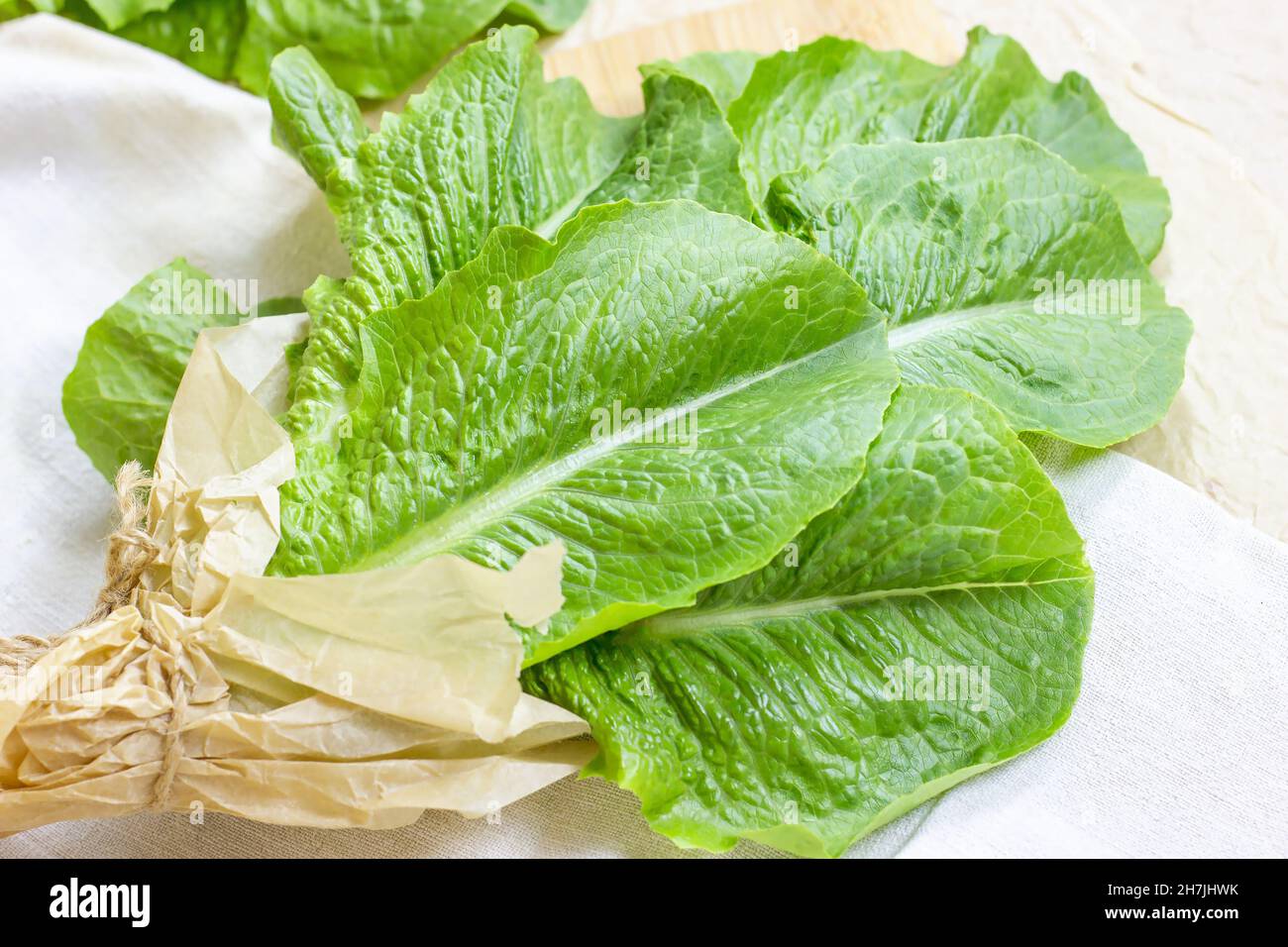 Fresh raw green romaine lettuce leaves for salad on light wooden ...