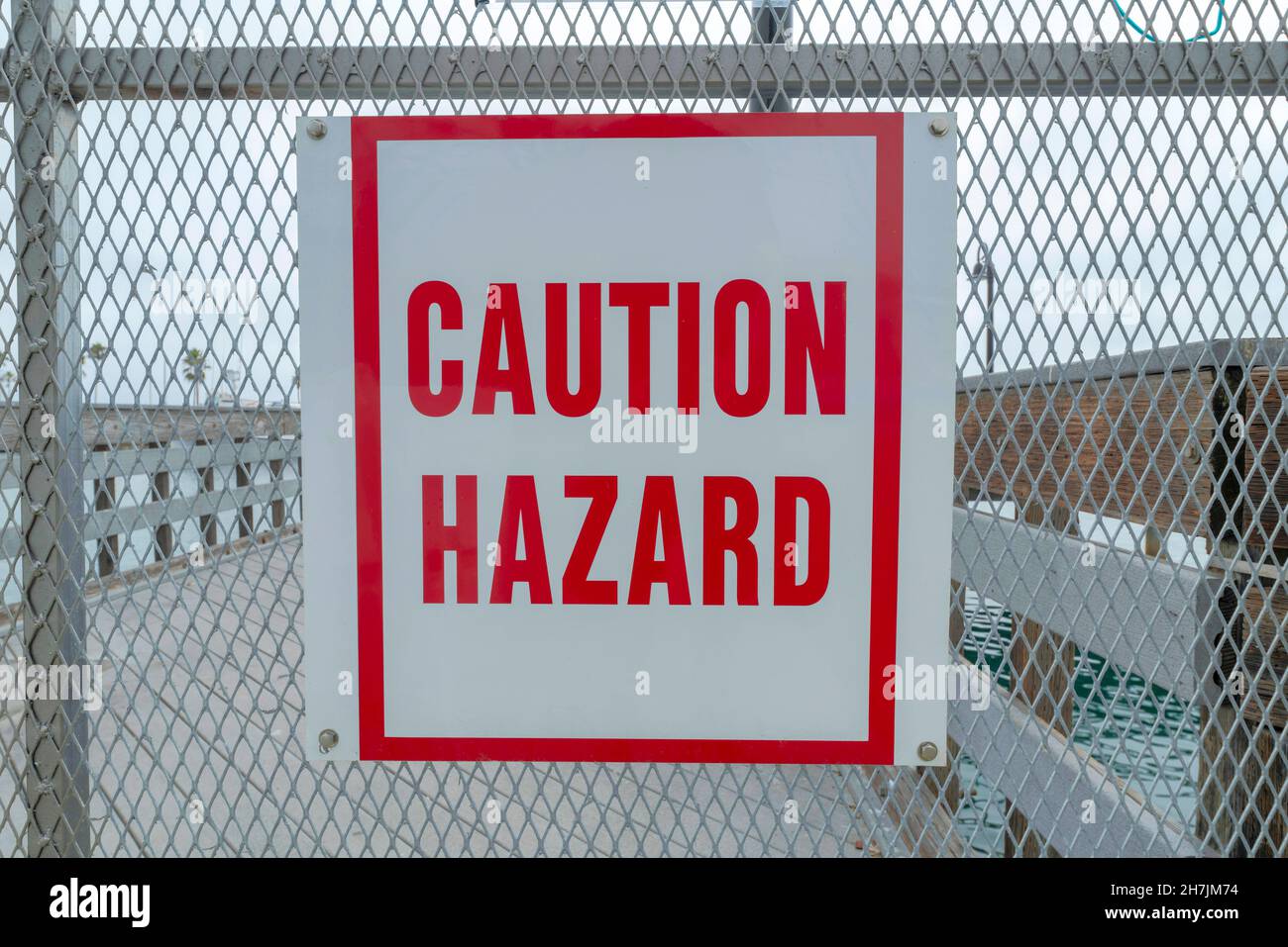 Caution Hazard sign on a metal wire rails at Oceanside, California ...