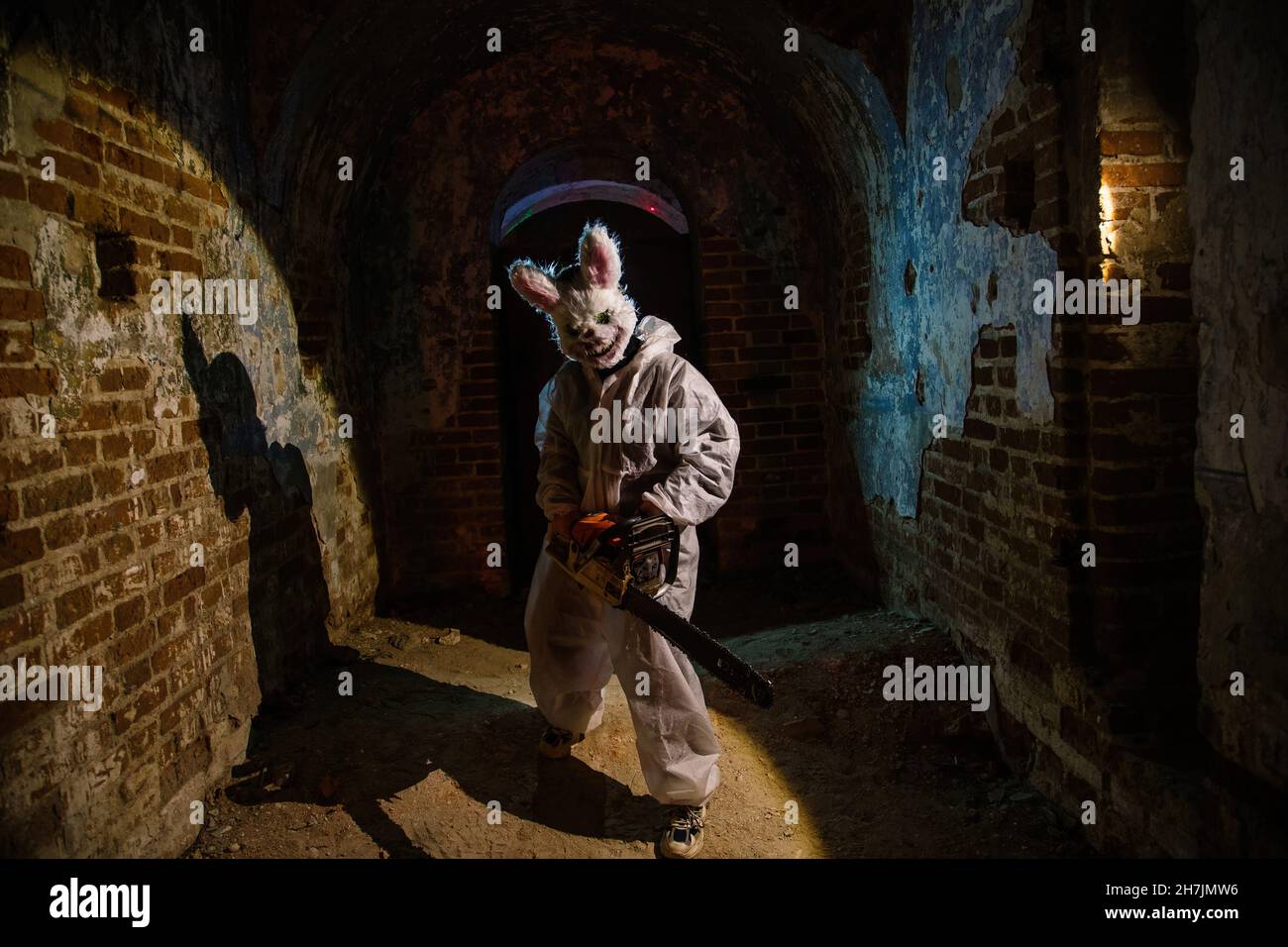 Maniac in mask of scary rabbit with chainsaw Stock Photo - Alamy