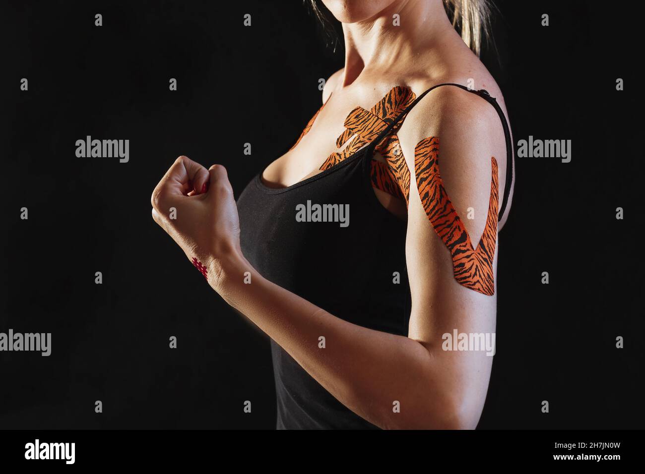 Kinesiological tape on the biceps and pectoral muscles of a young woman ...