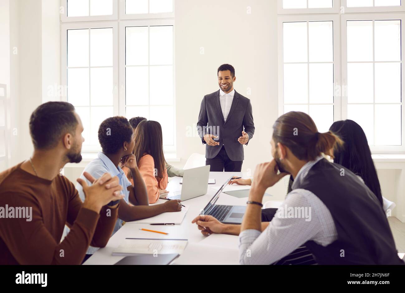 Young ambitious male employee speaks to colleagues at business meeting ...