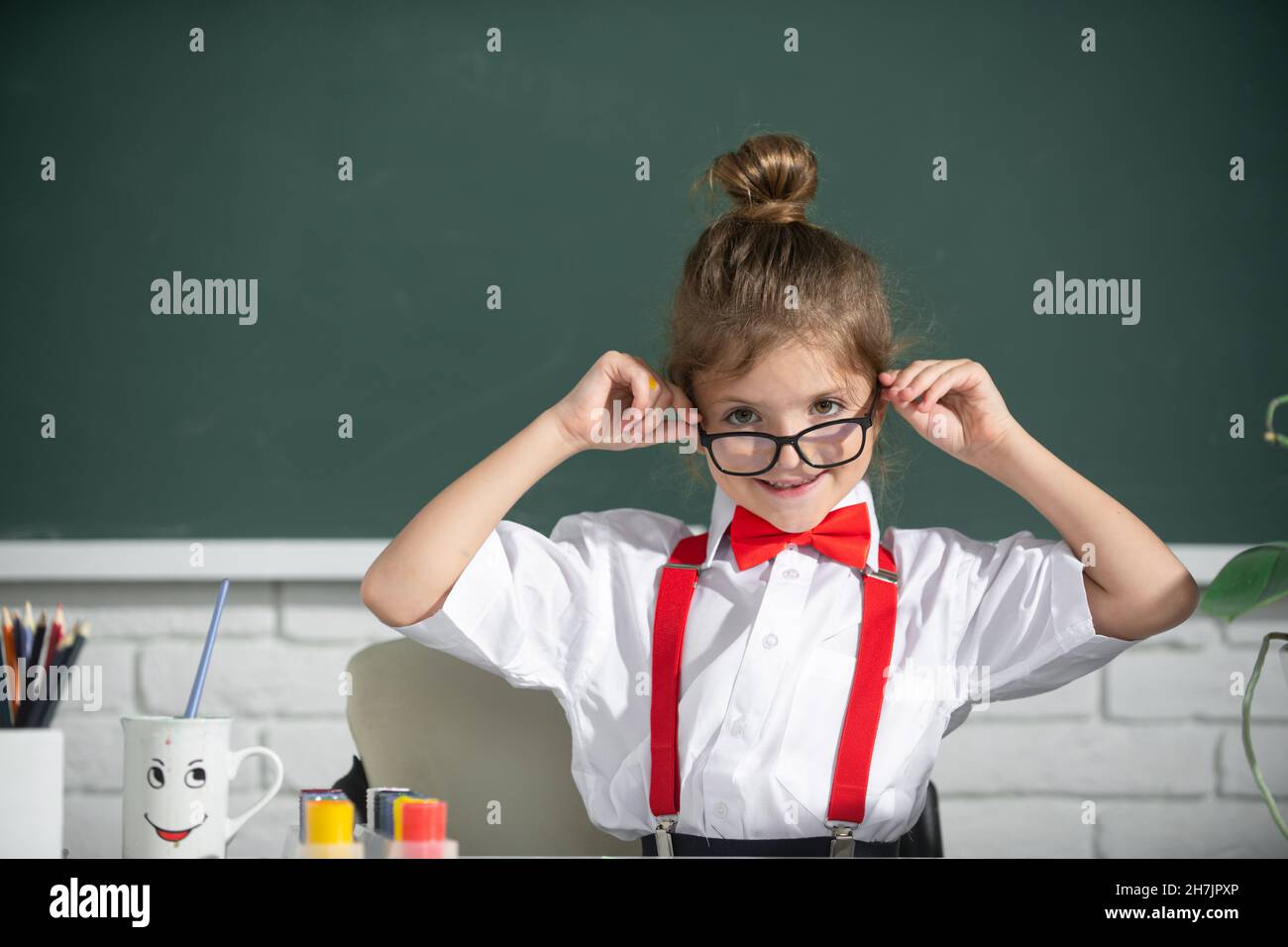 Cute child at school. Kid is learning in class on background of ...