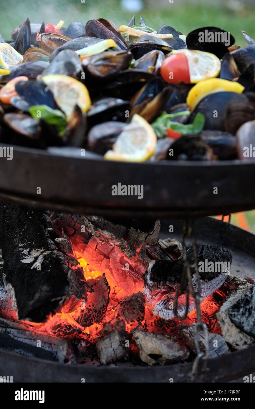 Side view on seafood grilling on bbq grill on backyard. Mussels in ...