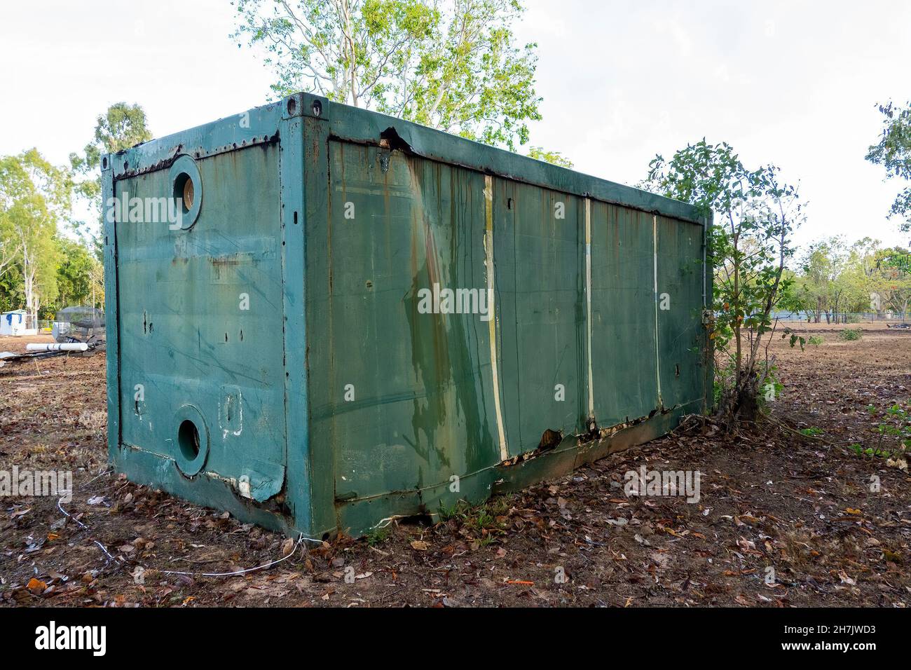 An old green storage container rusting and falling apart in a rural ...