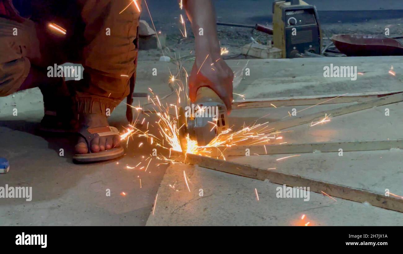 A photo of a worker who is using a grinder in Asia Stock Photo - Alamy