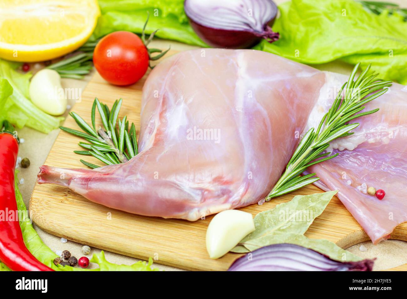 Raw uncooked pink rabbit leg meat with green rosemary and fresh ...