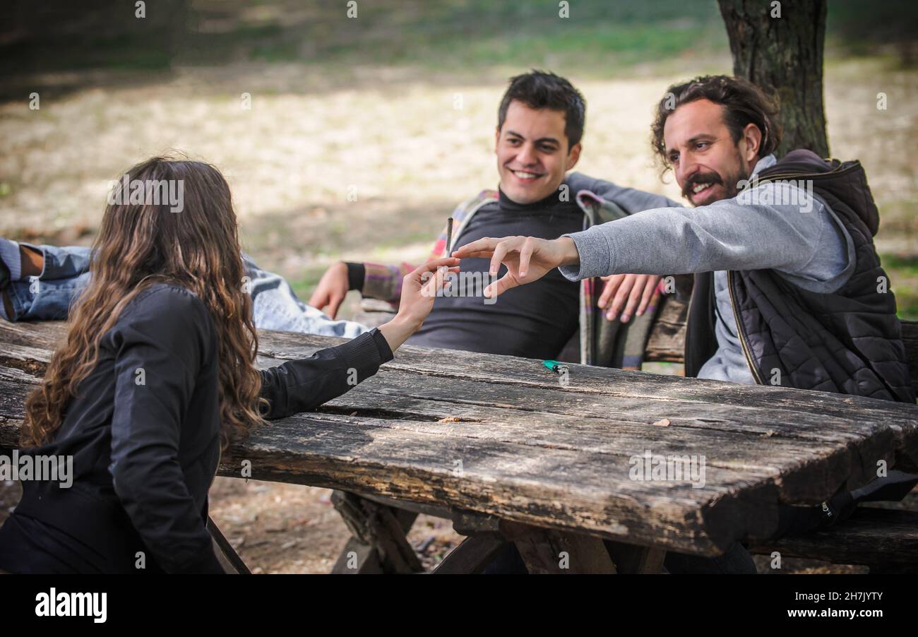 Young friends gives from hand to hand each other ganja joint. Smoking ...