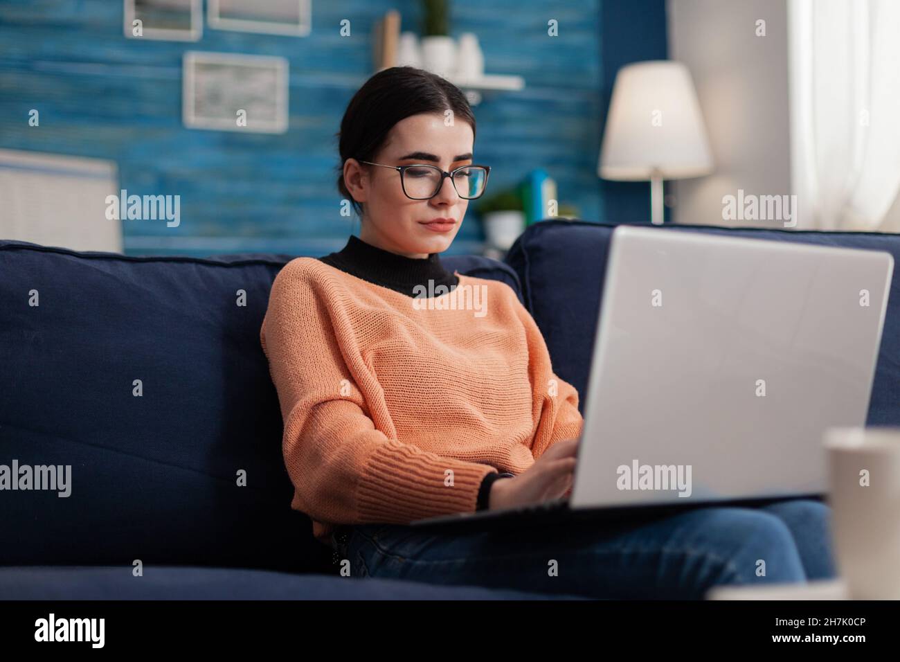 Student influencer on couch holding laptop and typing. Programmer with ...
