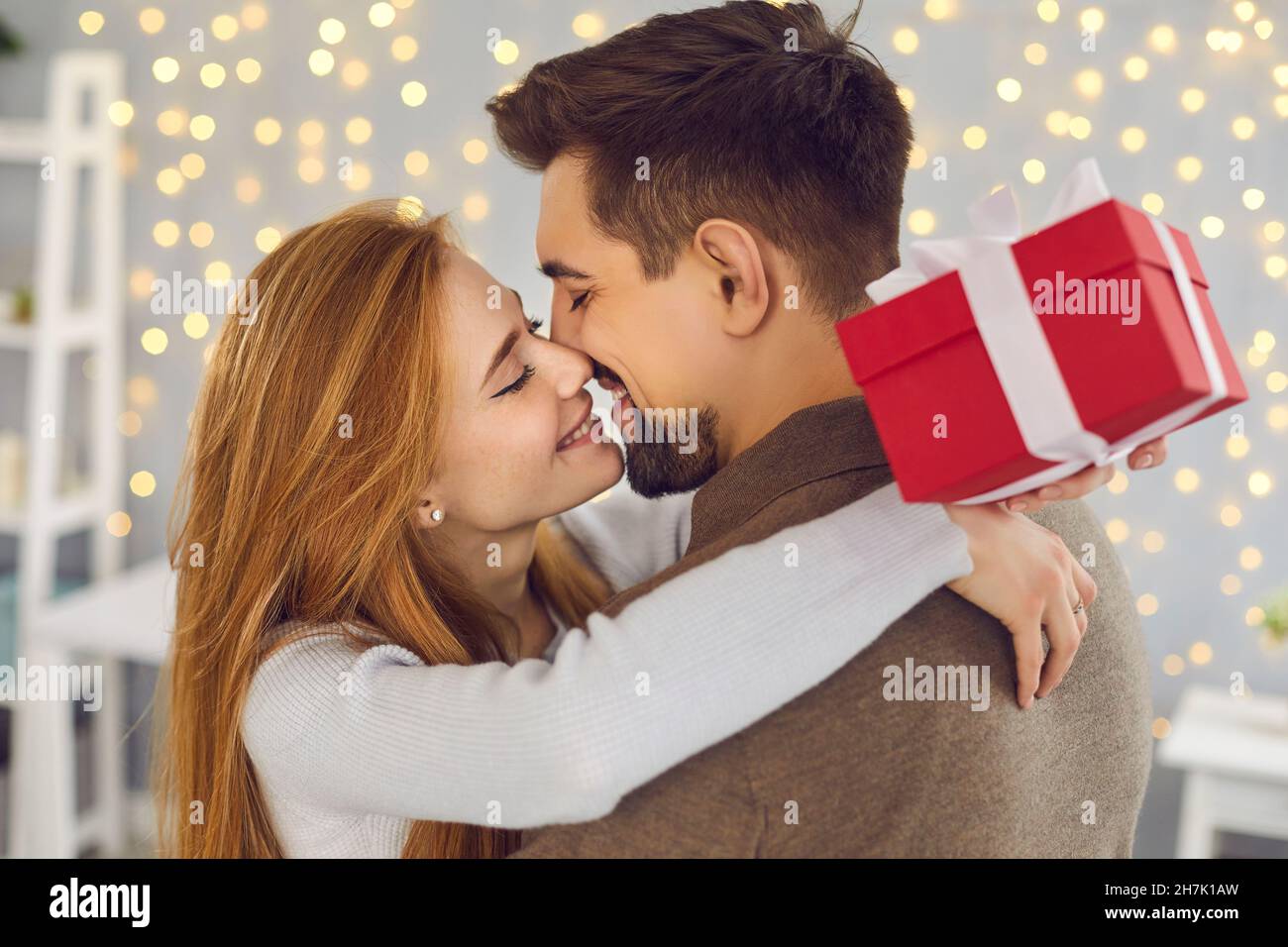 Close up of two lovers hugging and kissing after exchanging gifts on ...