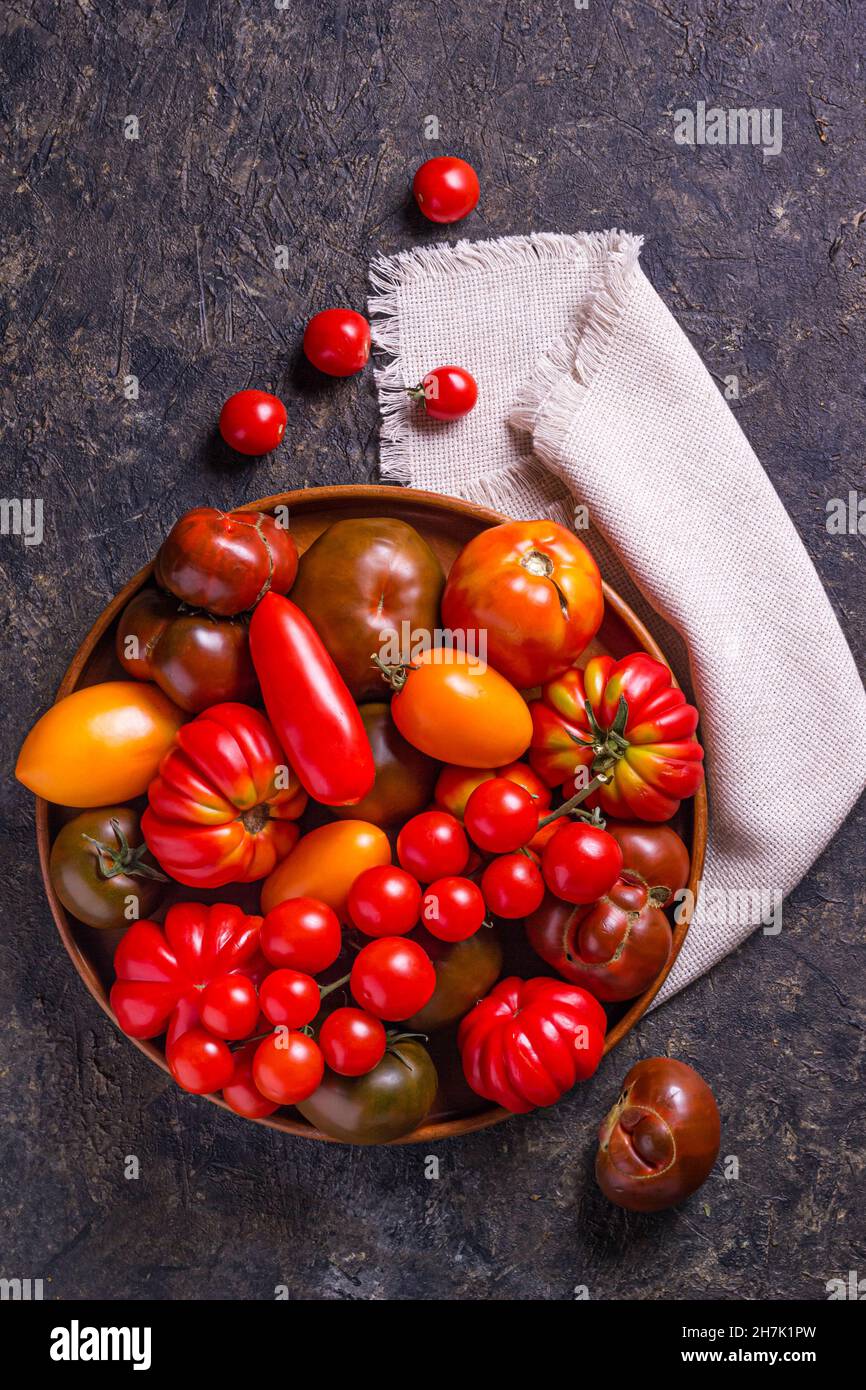 The harvest of assorted tomatoes. Colorful organic tomatoes on a large ...