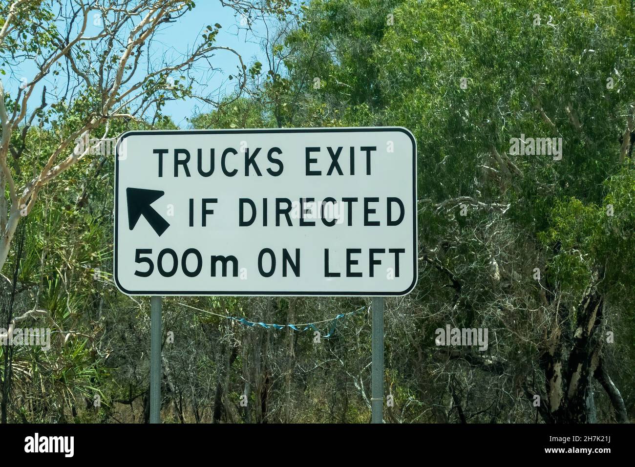 Trucks exit if direction road sign amongst bushland Stock Photo - Alamy