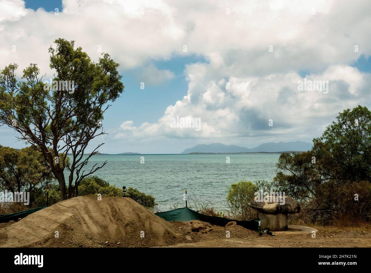 Ocean view landscape beyond roadworks on side of highway under a cloudy ...