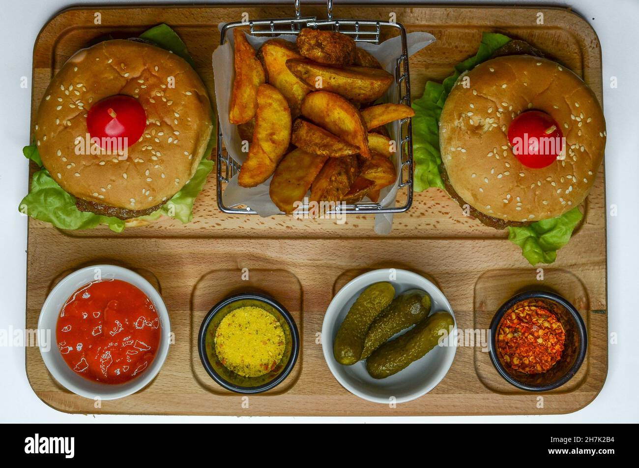 Closeup shot of two burgers with some fries in the middle Stock Photo ...