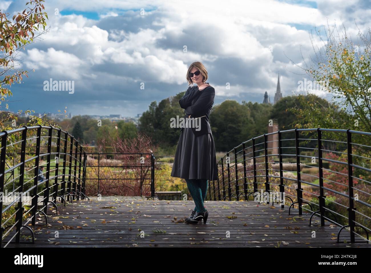 Young woman in dress, standing on a pedestrian bridge Stock Photo - Alamy