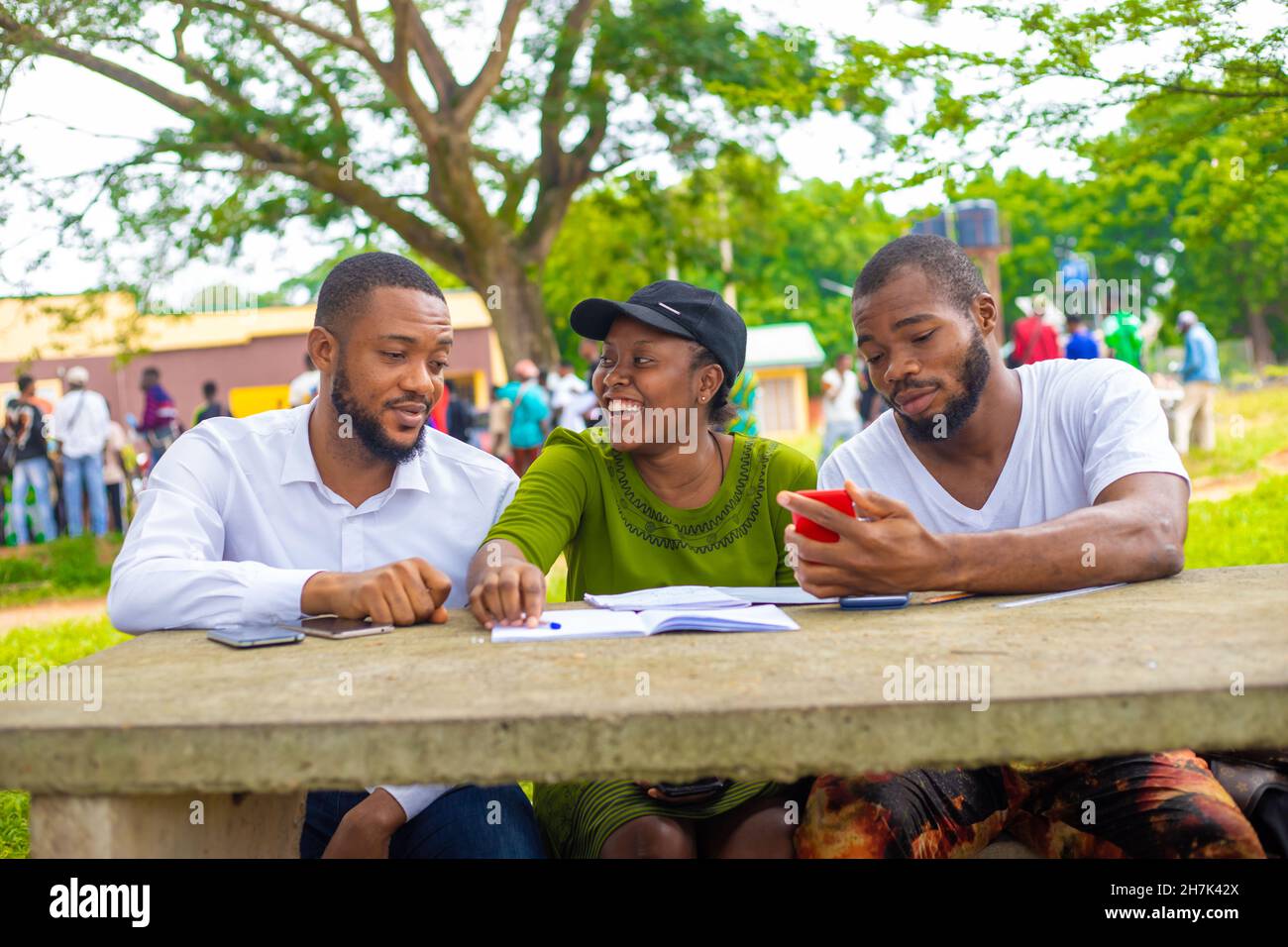 African friends student sitting by the table in the campus park and ...