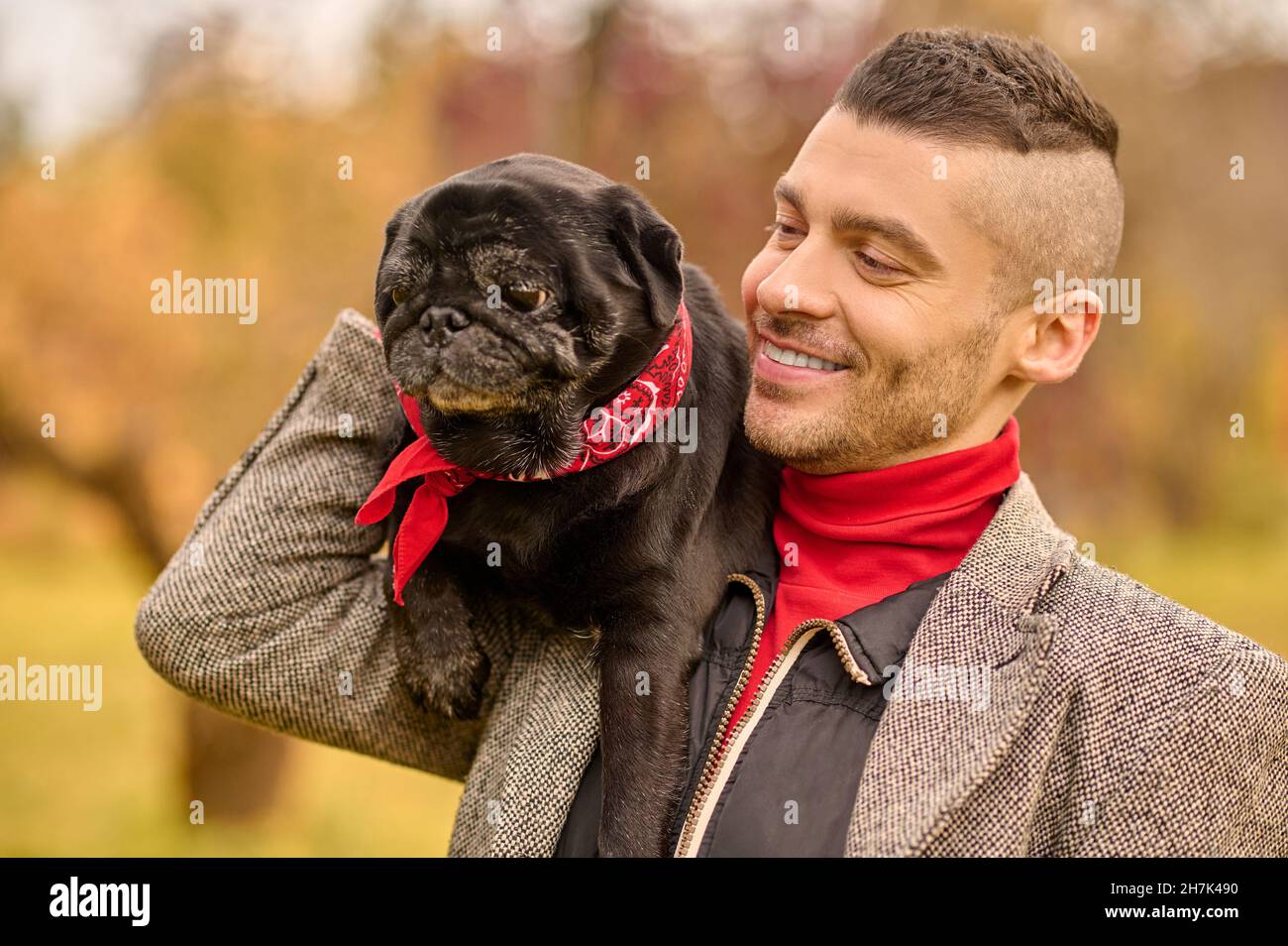 A happy smiling man with his dog in the park Stock Photo - Alamy