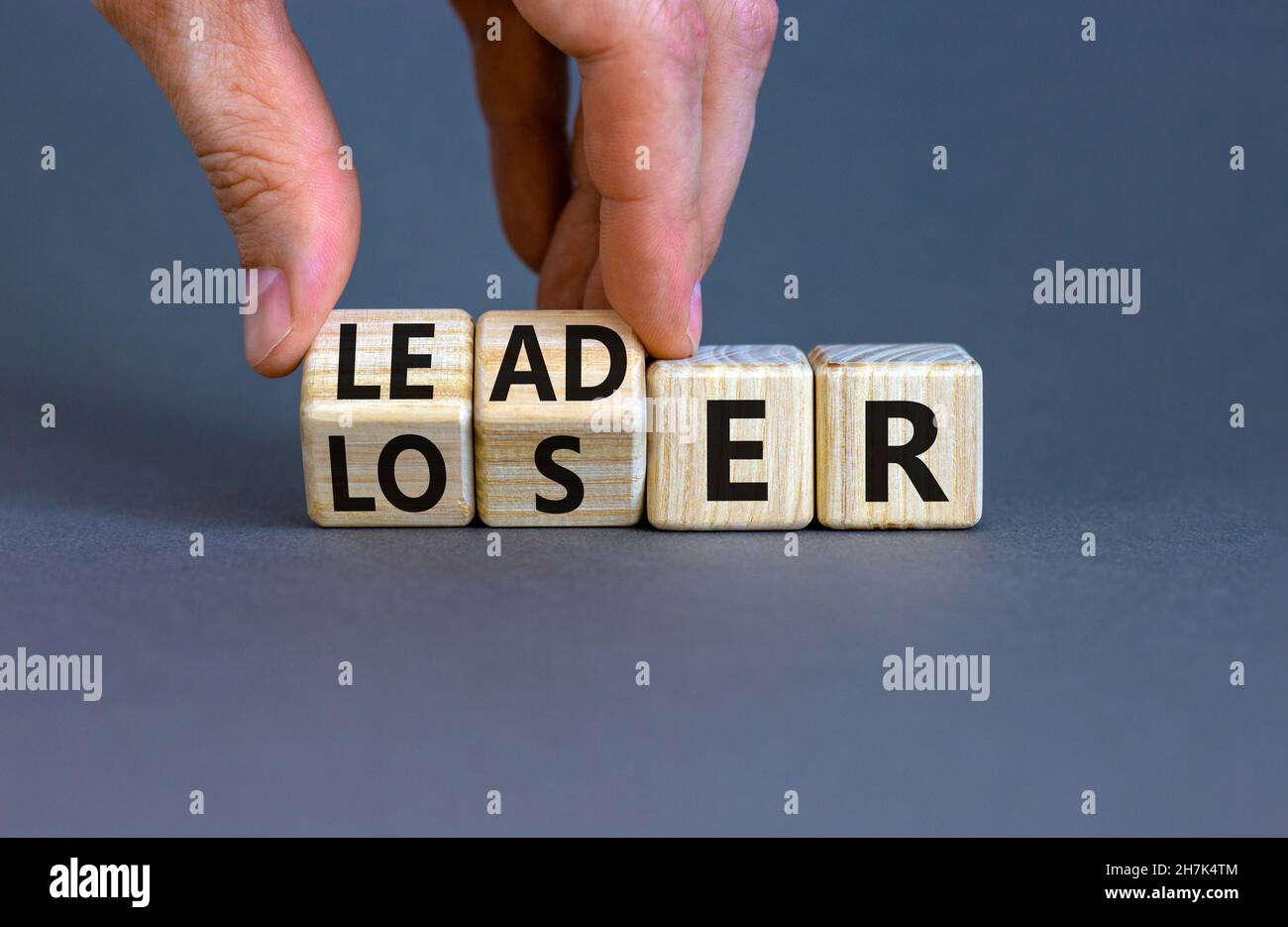 Loser or leader symbol. Businessman turns cubes and changes the word ...