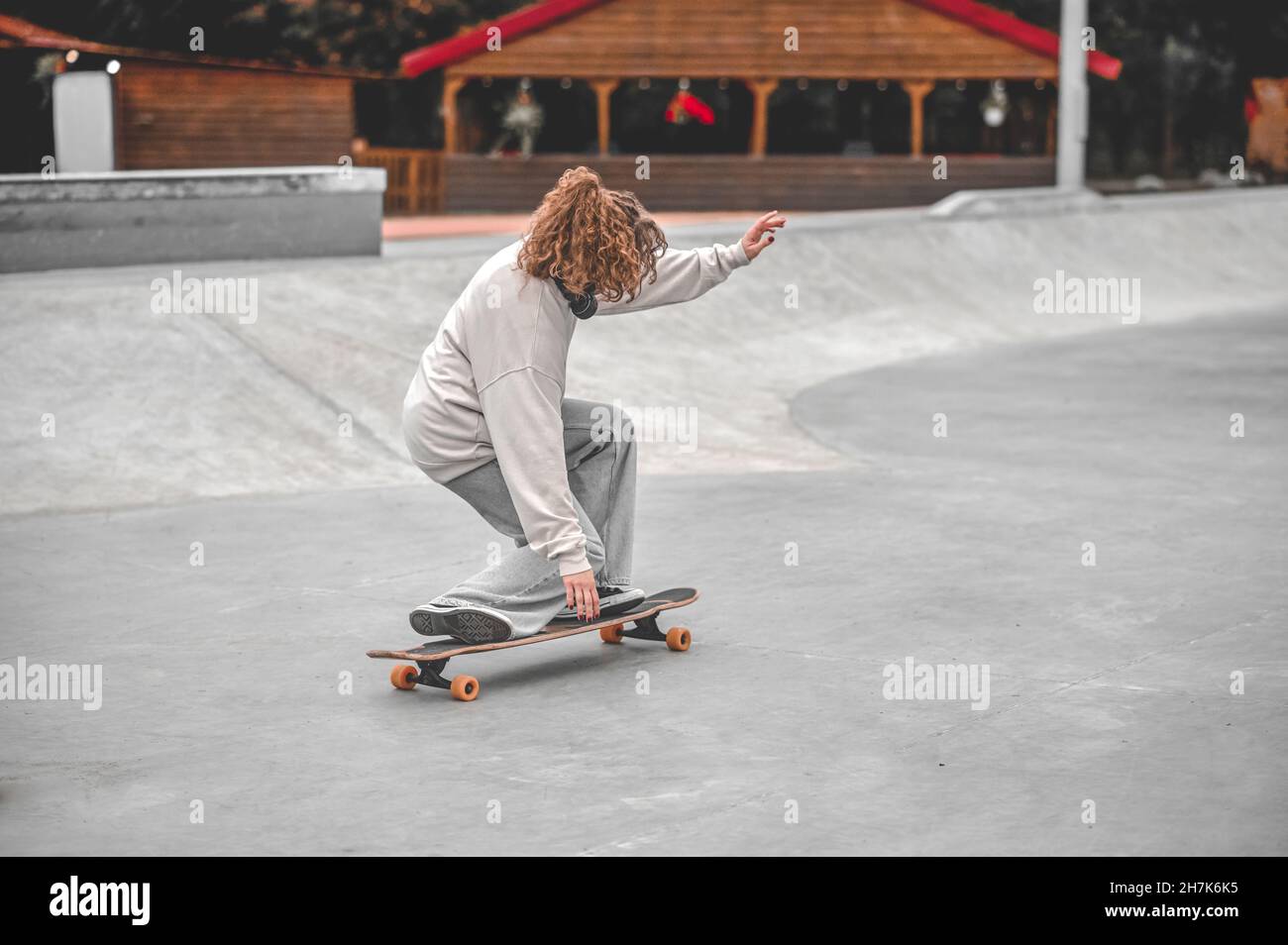 Girl on bent legs balancing on skateboard Stock Photo - Alamy