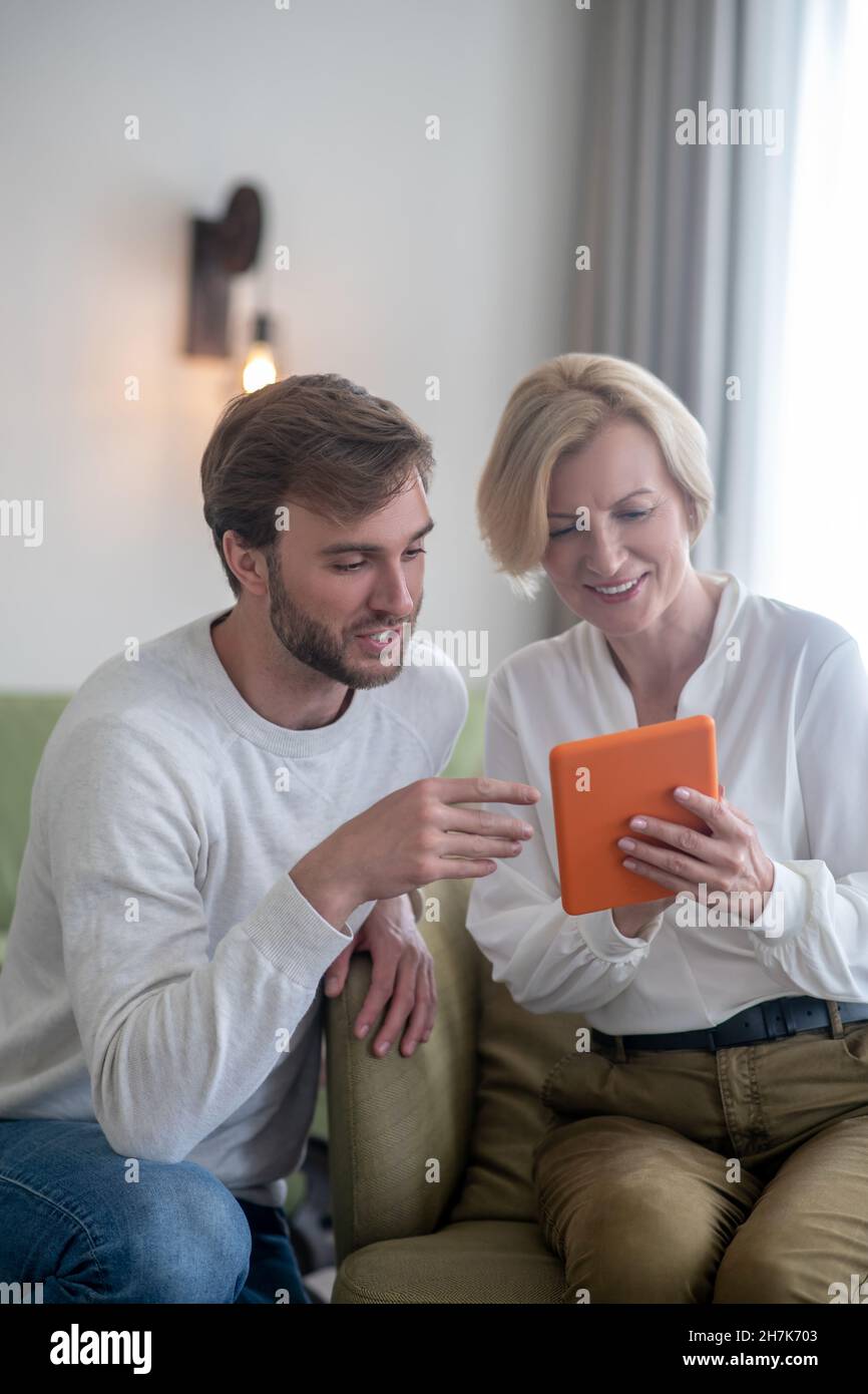 Two people looking through the photos on a tablet Stock Photo - Alamy