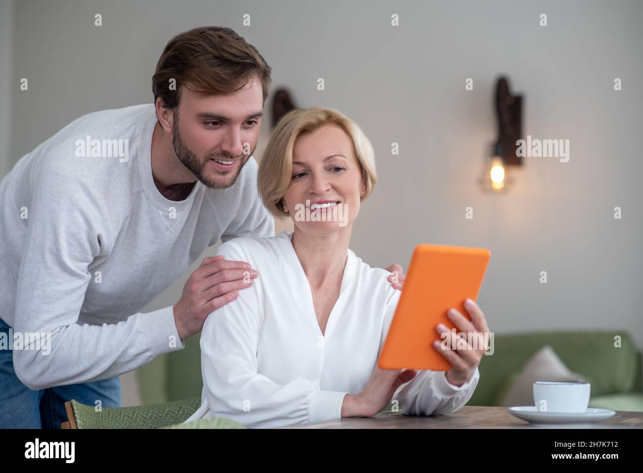 Two people looking through the photos on a tablet Stock Photo - Alamy