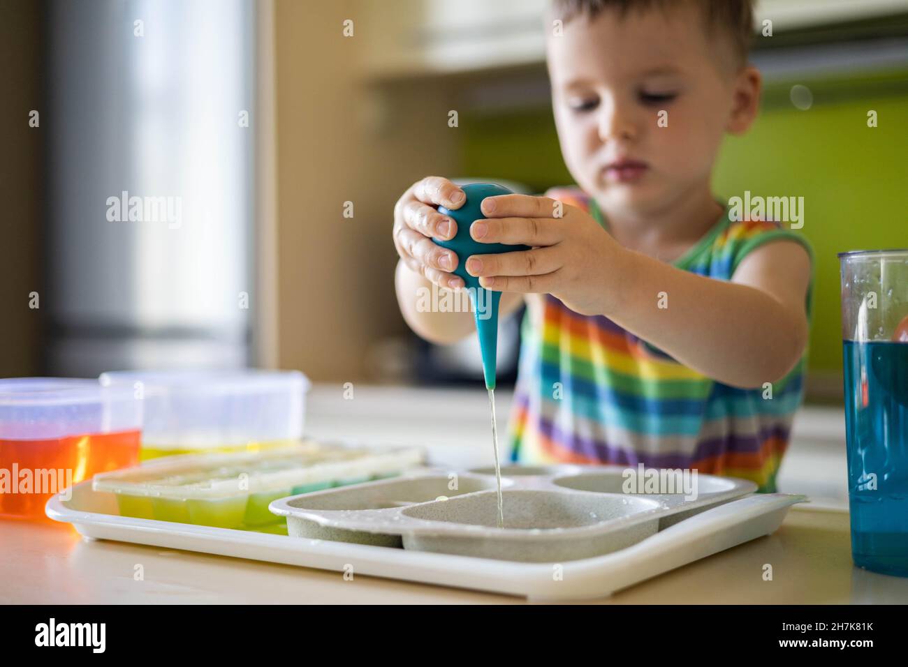 Cute baby boy learning mixing different colors with water and paint in ...