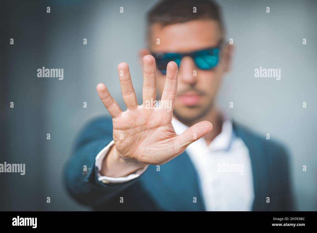 Bodyguard showing stop gesture with hand. Security guard blocks ...