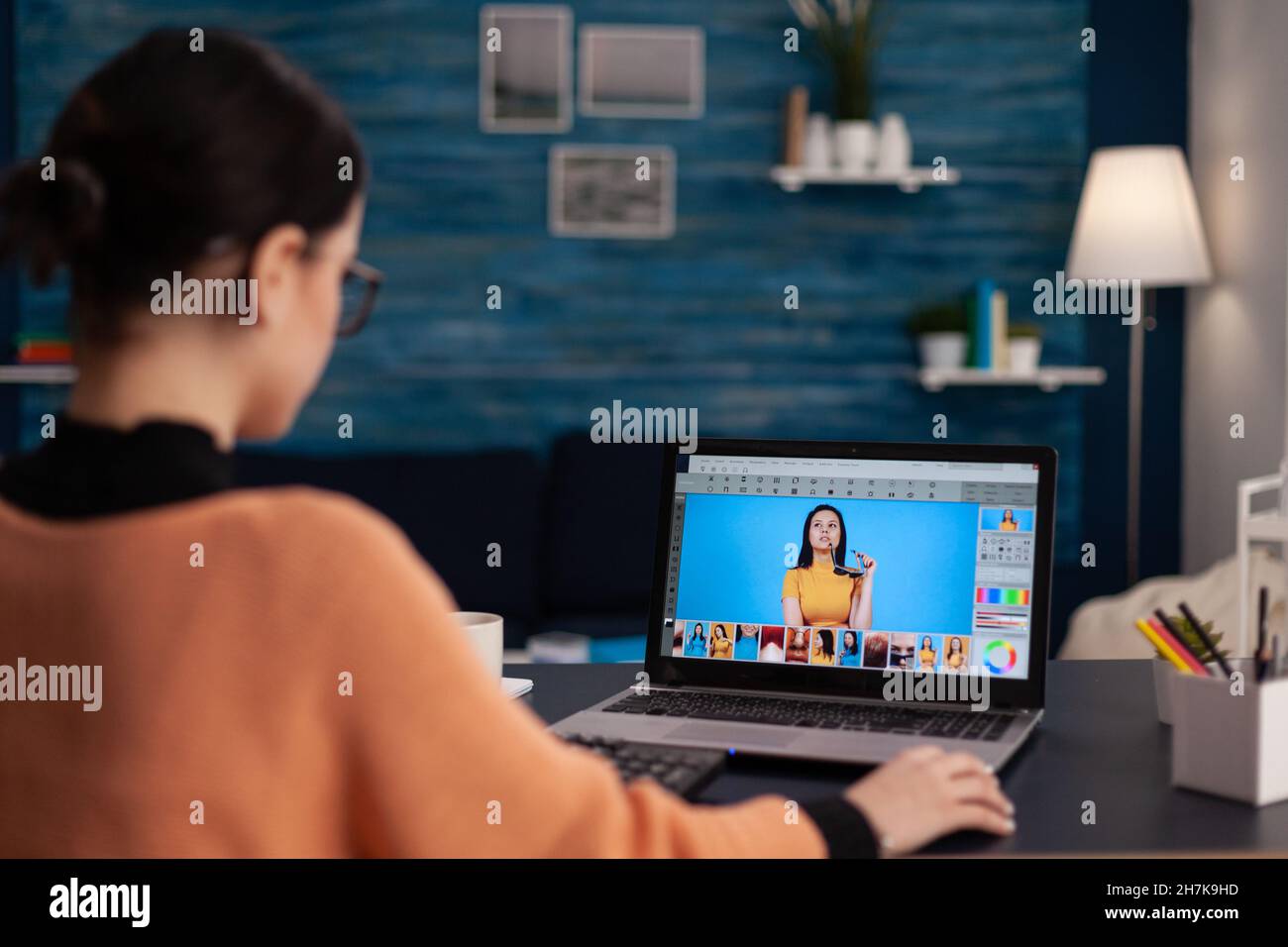 Student retouching photos on laptop. Freelancer photo editor working ...