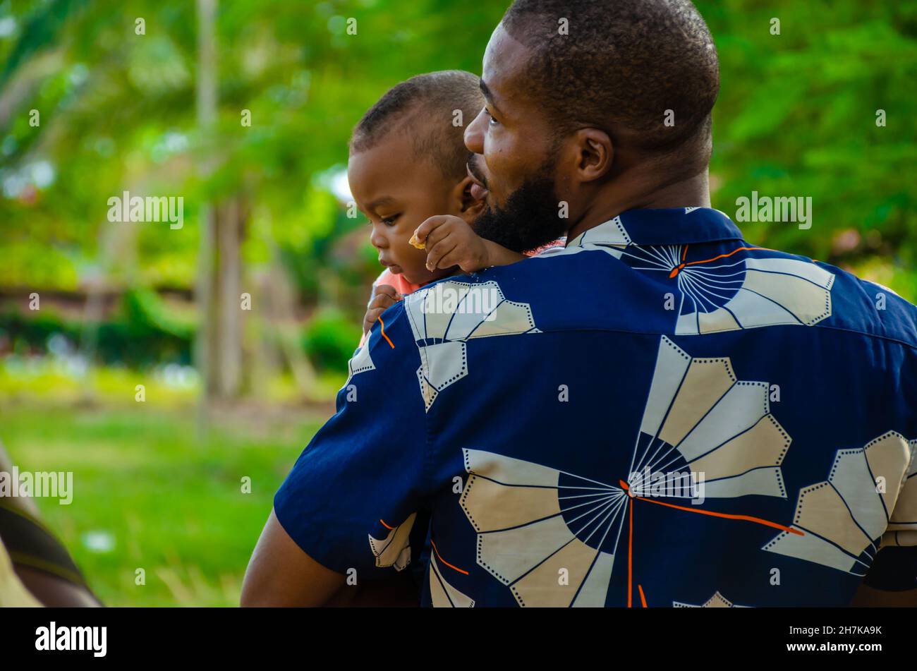 Back view of an African father holding his child Stock Photo - Alamy