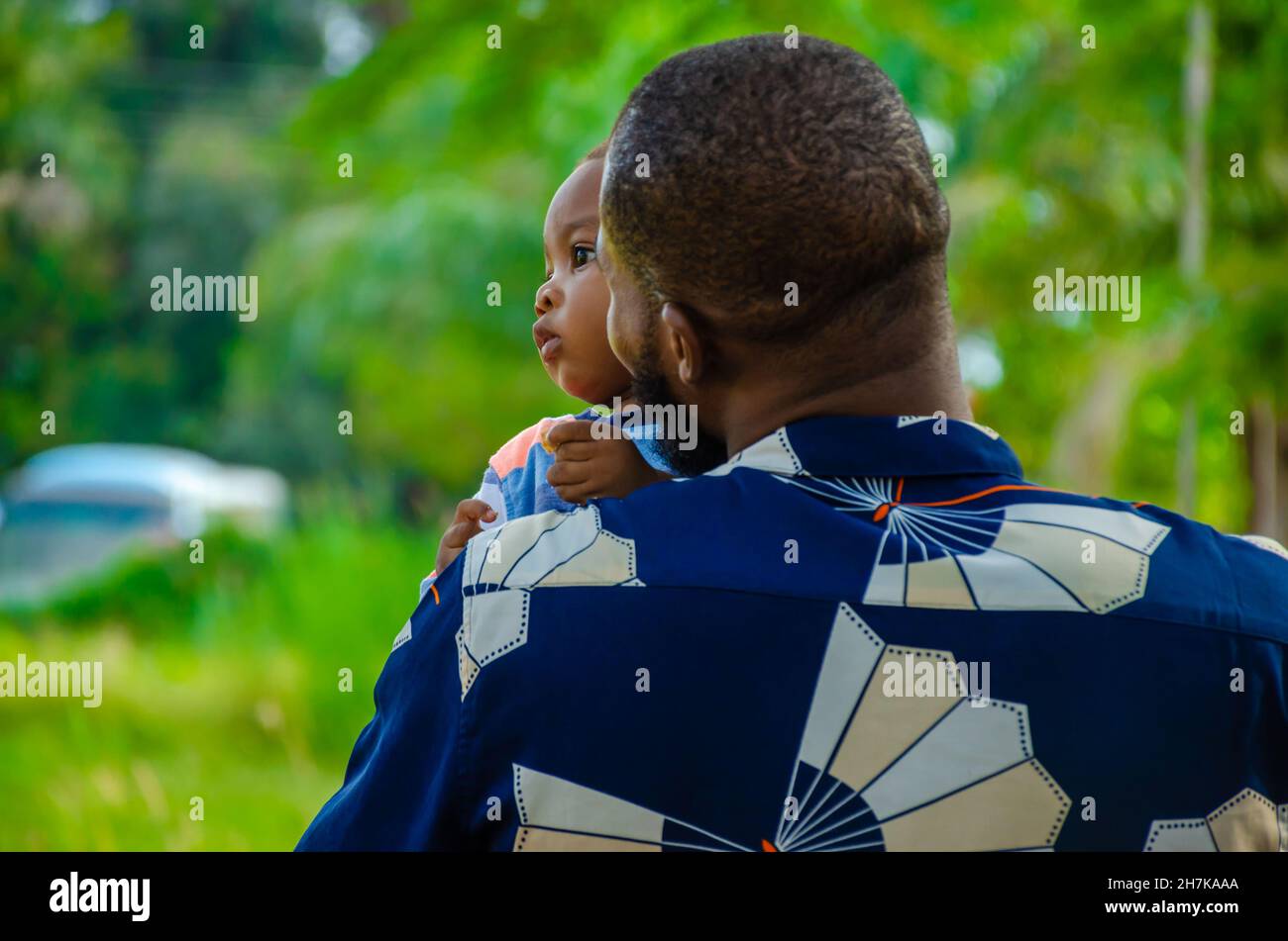 Back view of an African father holding his child Stock Photo - Alamy