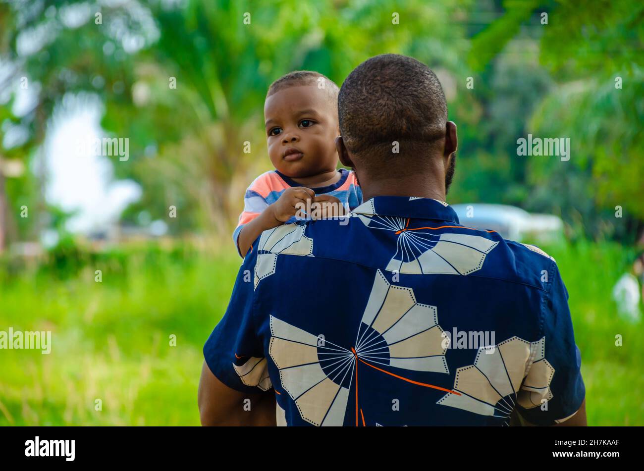 Back view of an African father holding his child Stock Photo - Alamy