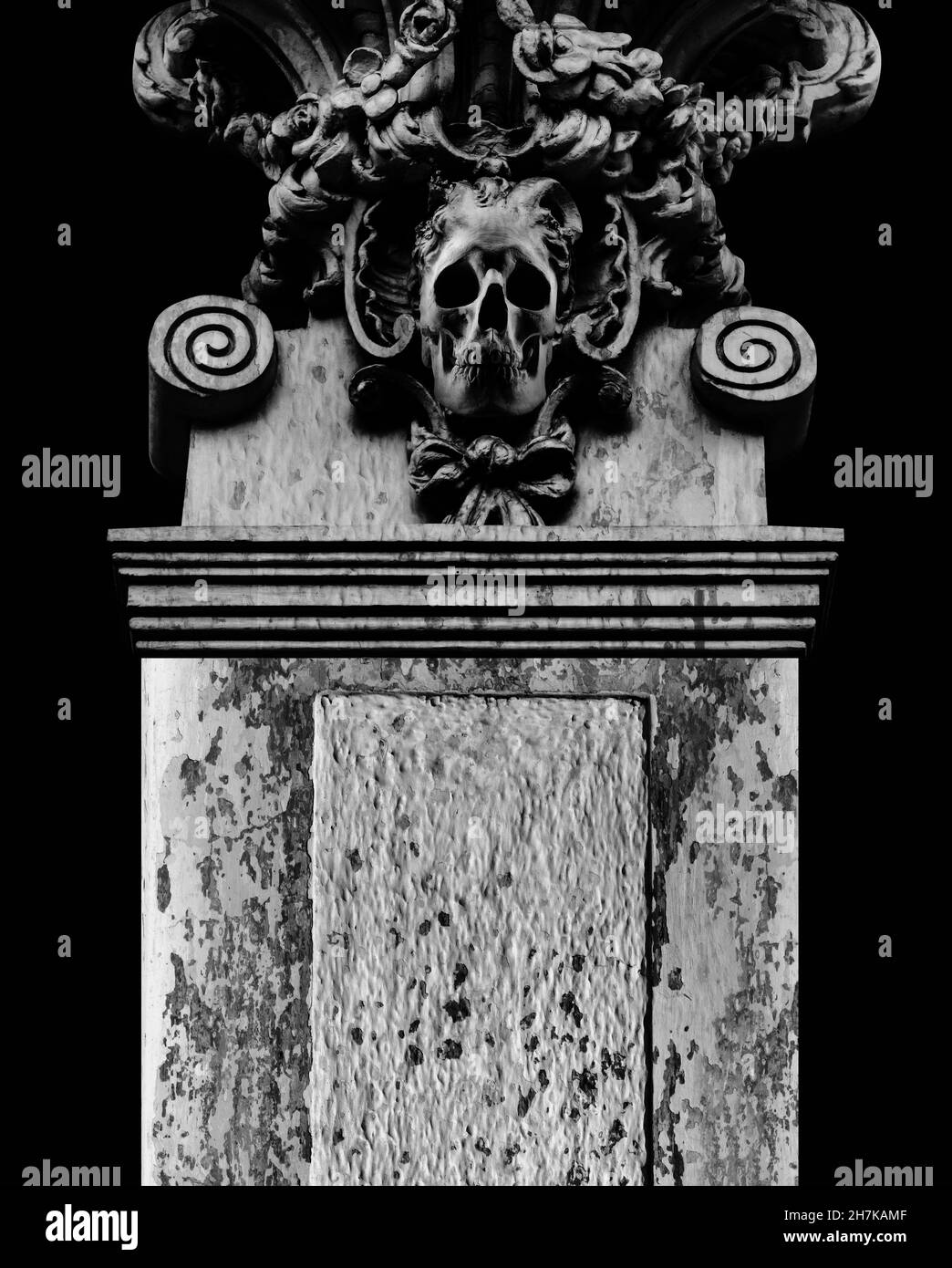 Photo of an acient old stone column with skull sculpture and decorative ...