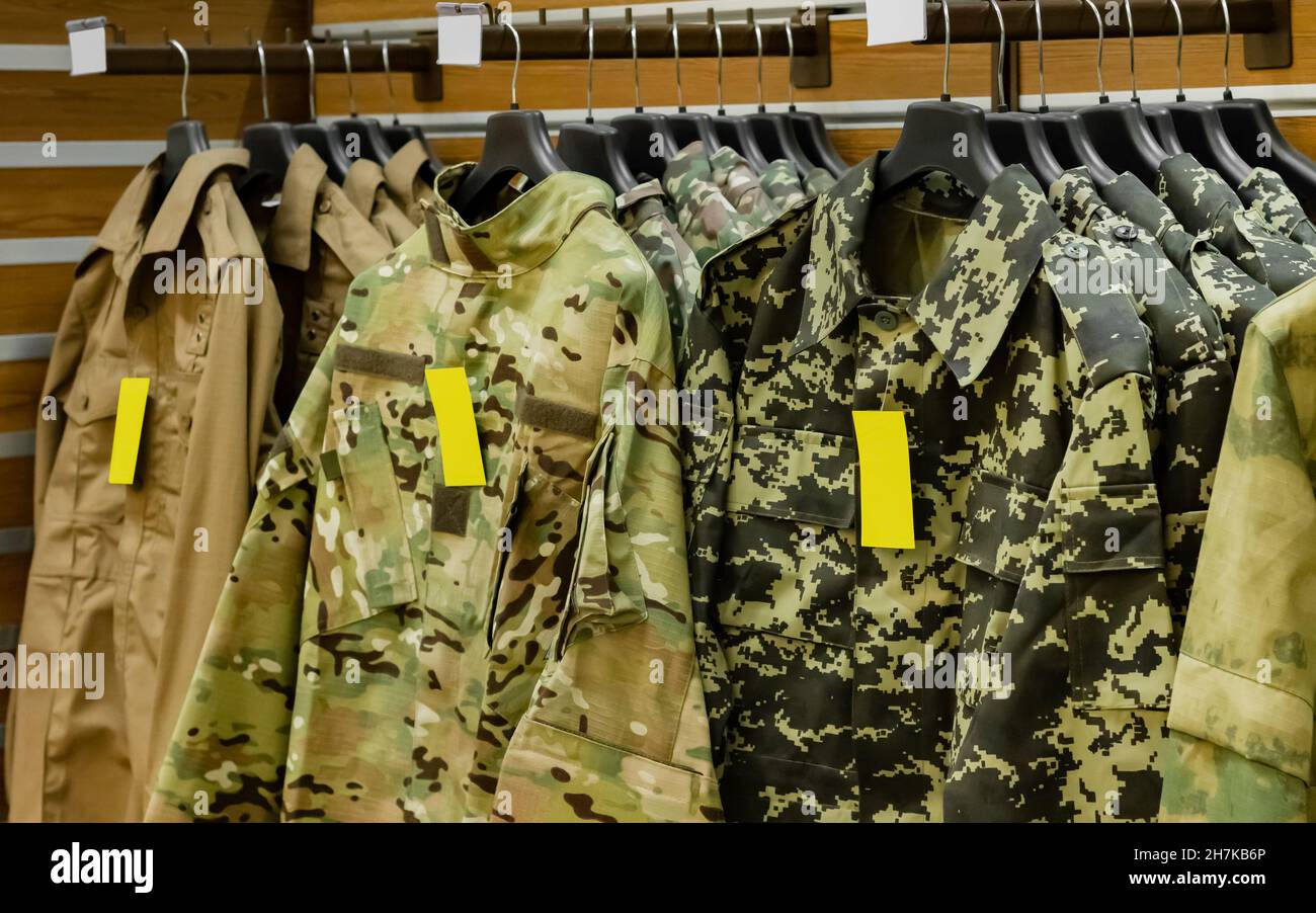 Photo of tactical military shirts hanging on store racks with sale and ...