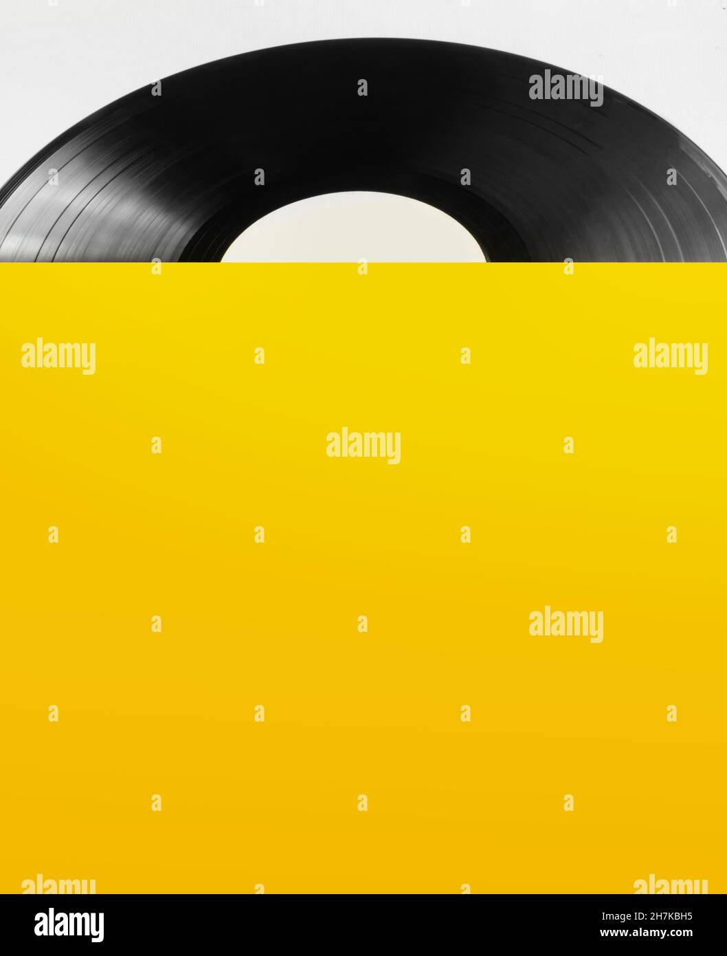 Photo of black vinyl plate with yellow cover laying on white background ...