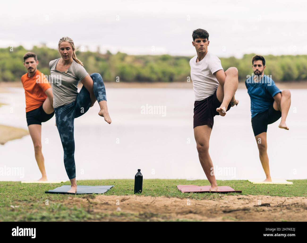 Yoga coach leading a yoga class next to a lake in a park Stock Photo ...