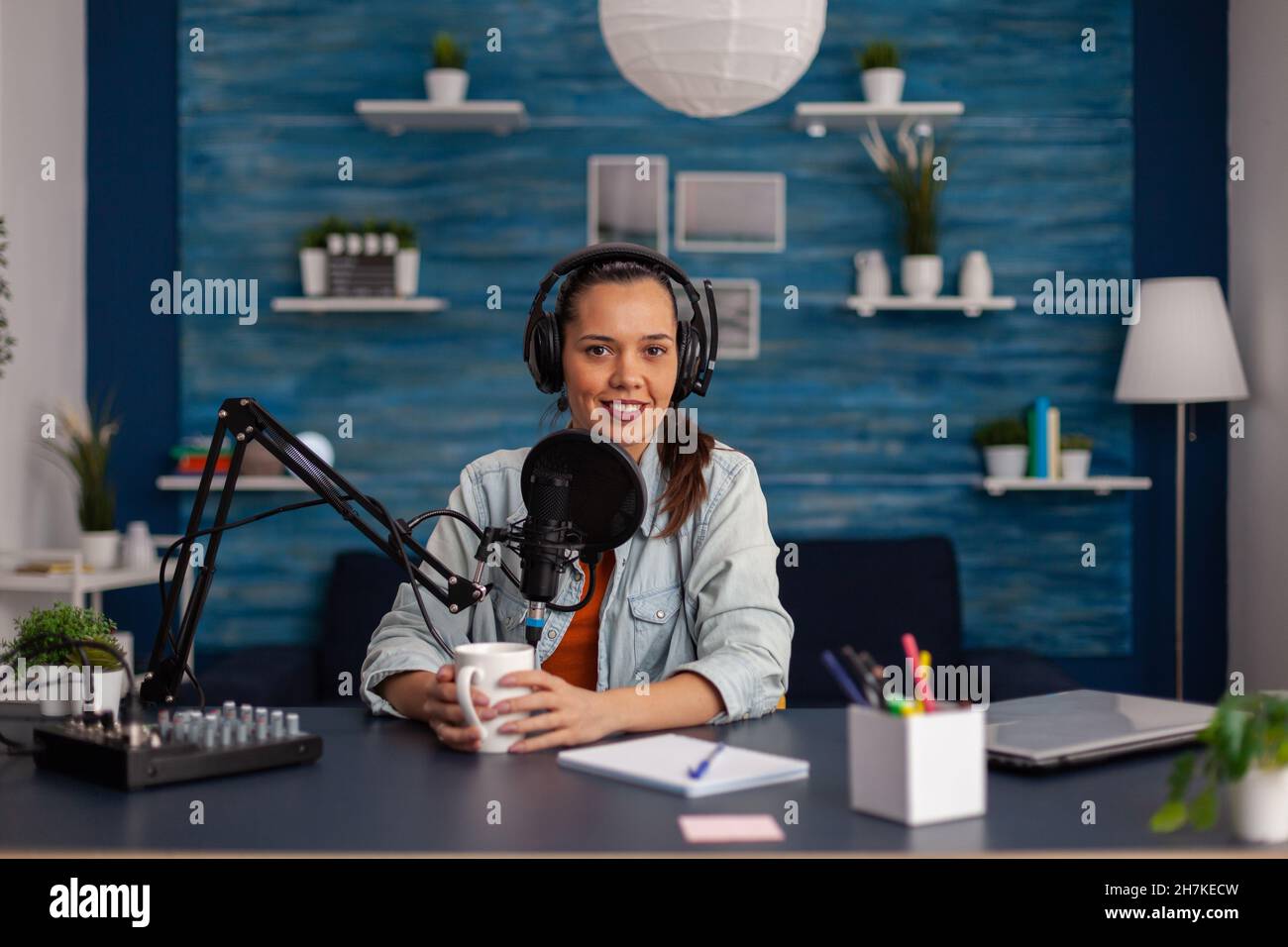 Portrait of social media influencer wearig headphones and streaming ...