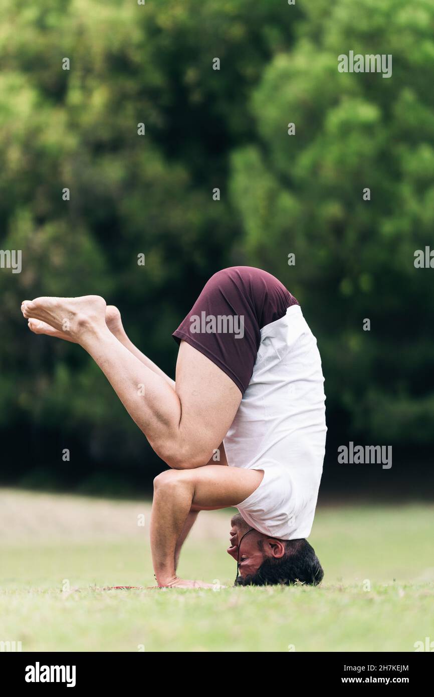 Man doing a inverted position of yoga with the head on the ground Stock ...