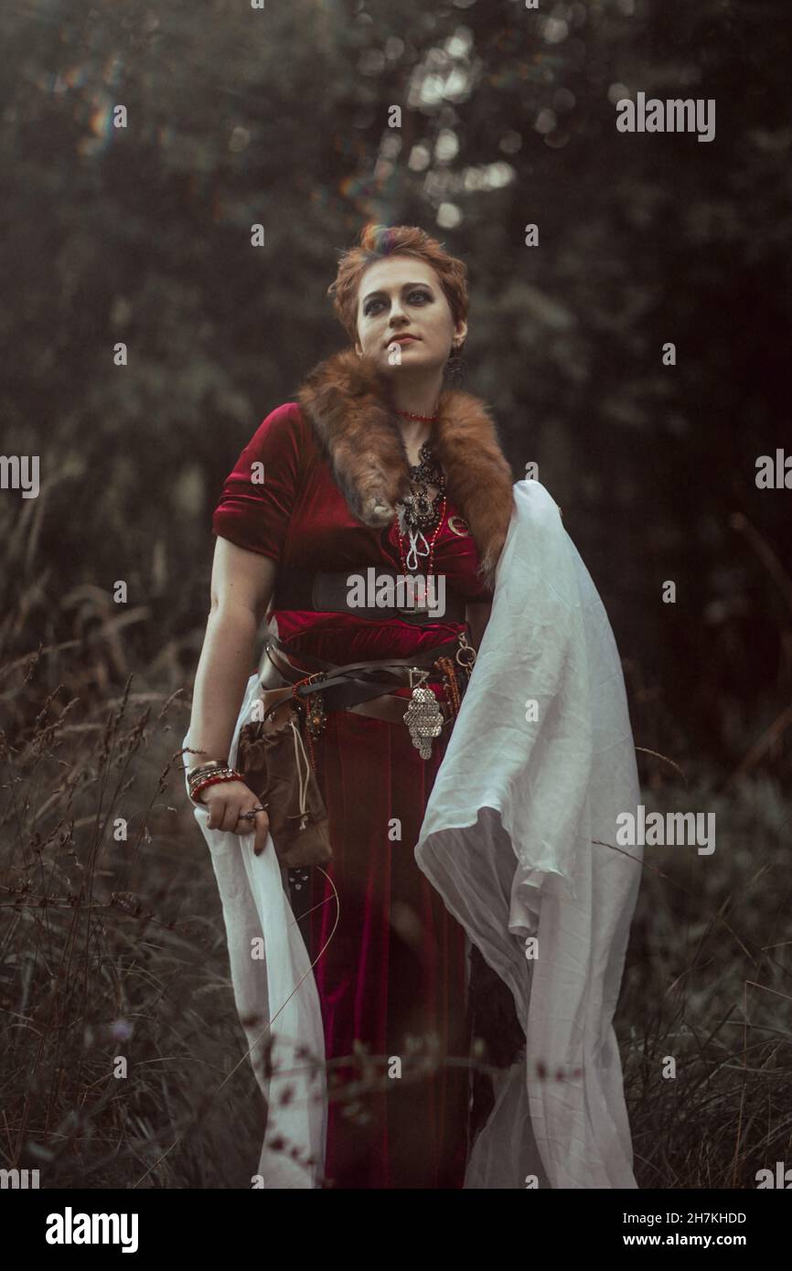 Witch with short hair in dress against the background of wild nature ...