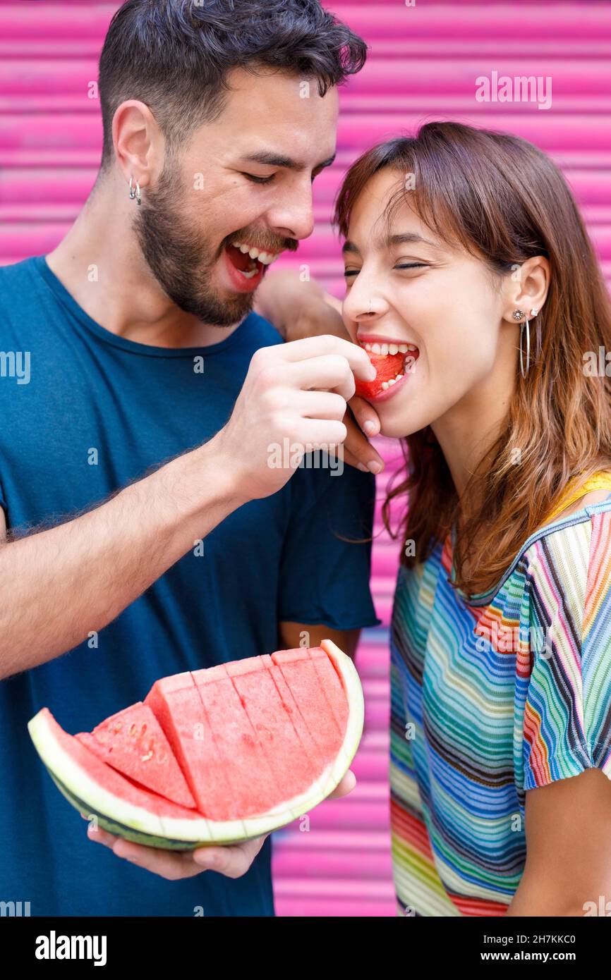 Cheerful boyfriend feeding watermelon to girlfriend Stock Photo - Alamy