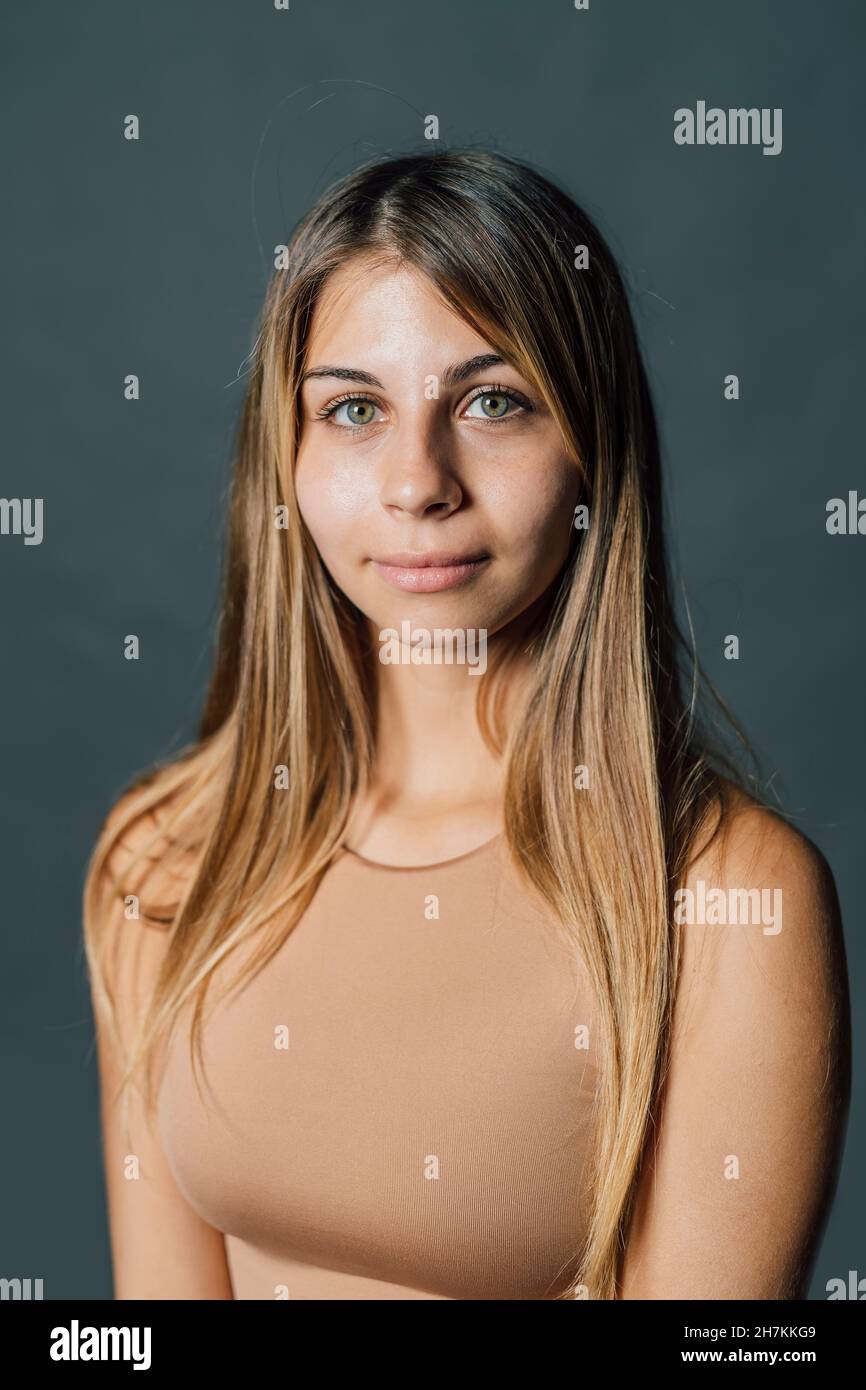Young woman with long hair against gray background Stock Photo - Alamy