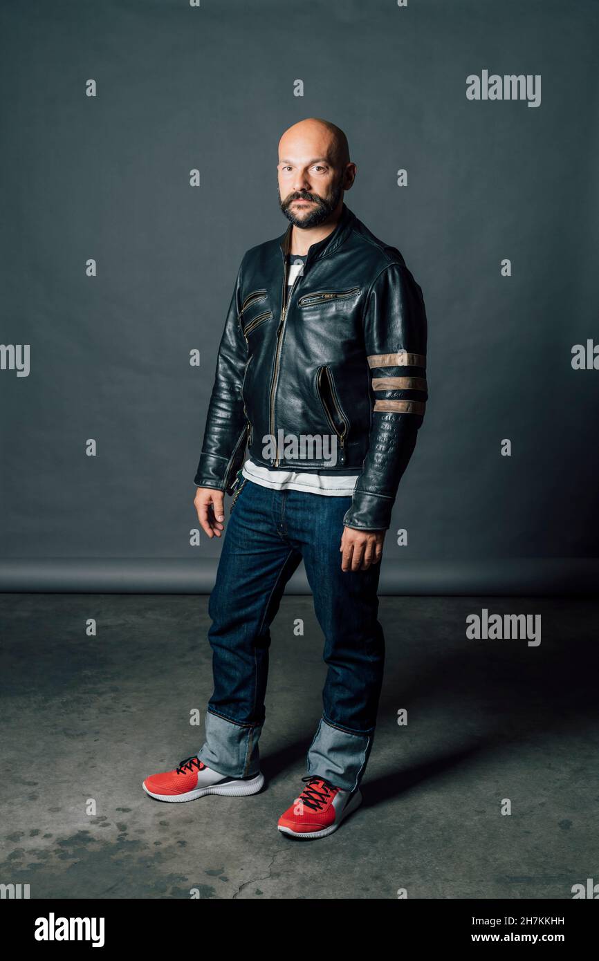 Confident bald man standing in front of gray backdrop Stock Photo - Alamy