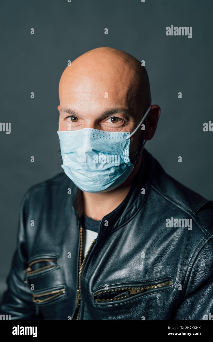 Bald man wearing protective face mask against gray background Stock ...