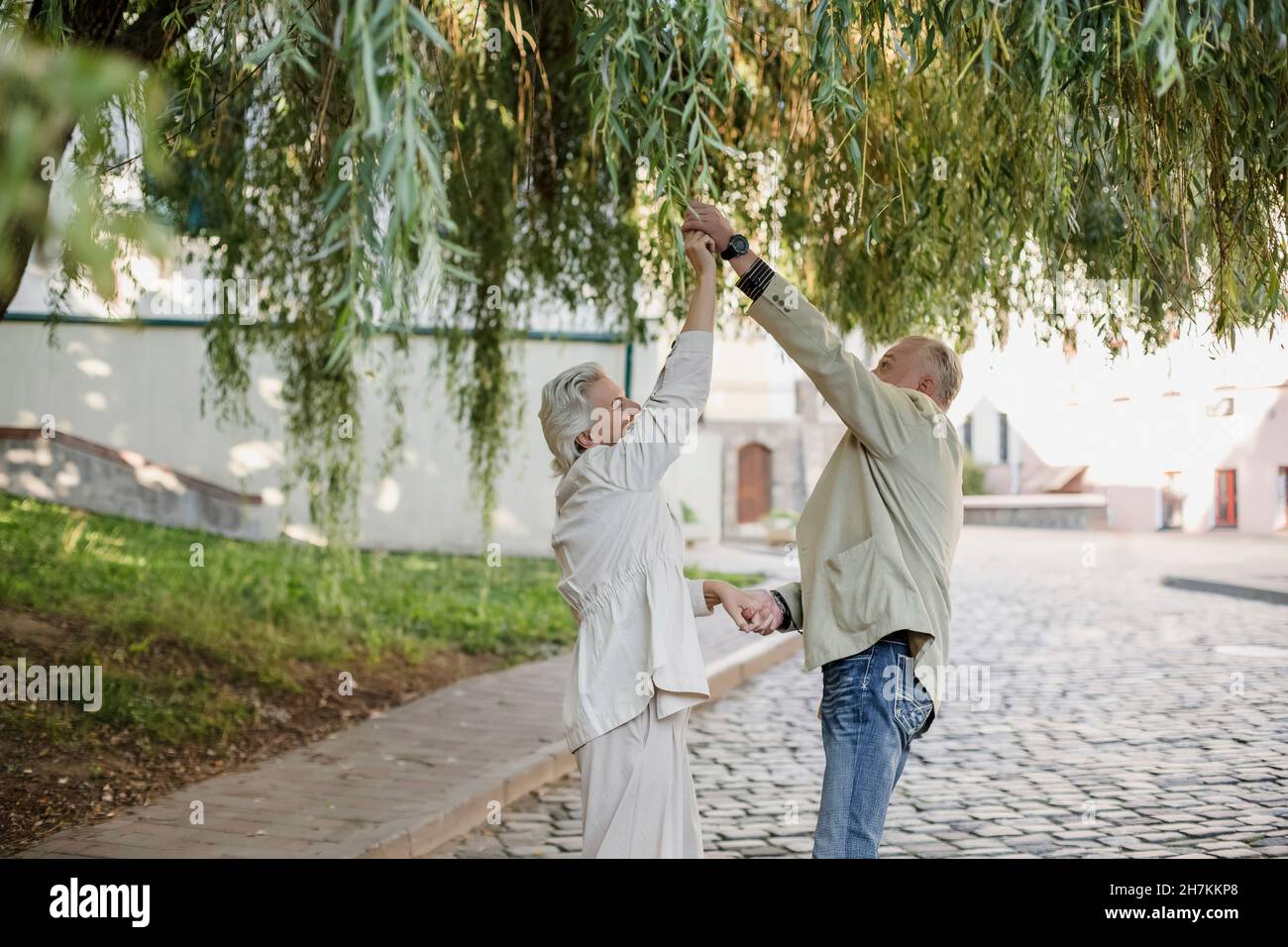 Happy couple dancing under tree Stock Photo - Alamy