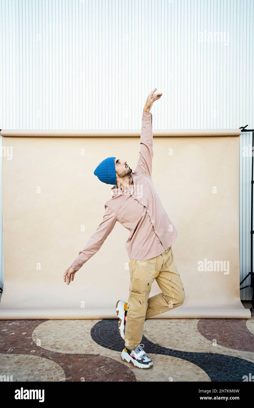 Mid adult male performer with hand raised dancing near backdrop Stock ...