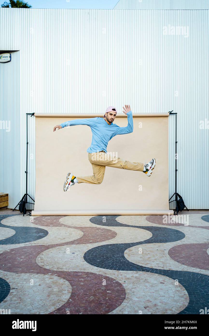 Mid adult man jumping by beige backdrop Stock Photo - Alamy