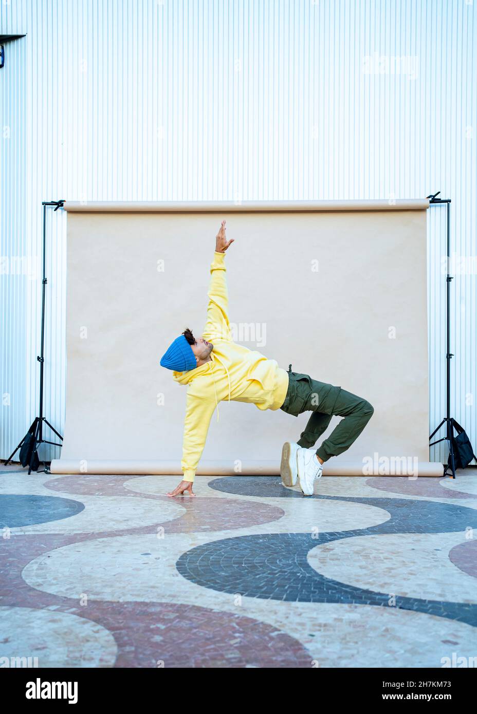 Young male performer balancing while dancing on floor by backdrop Stock ...