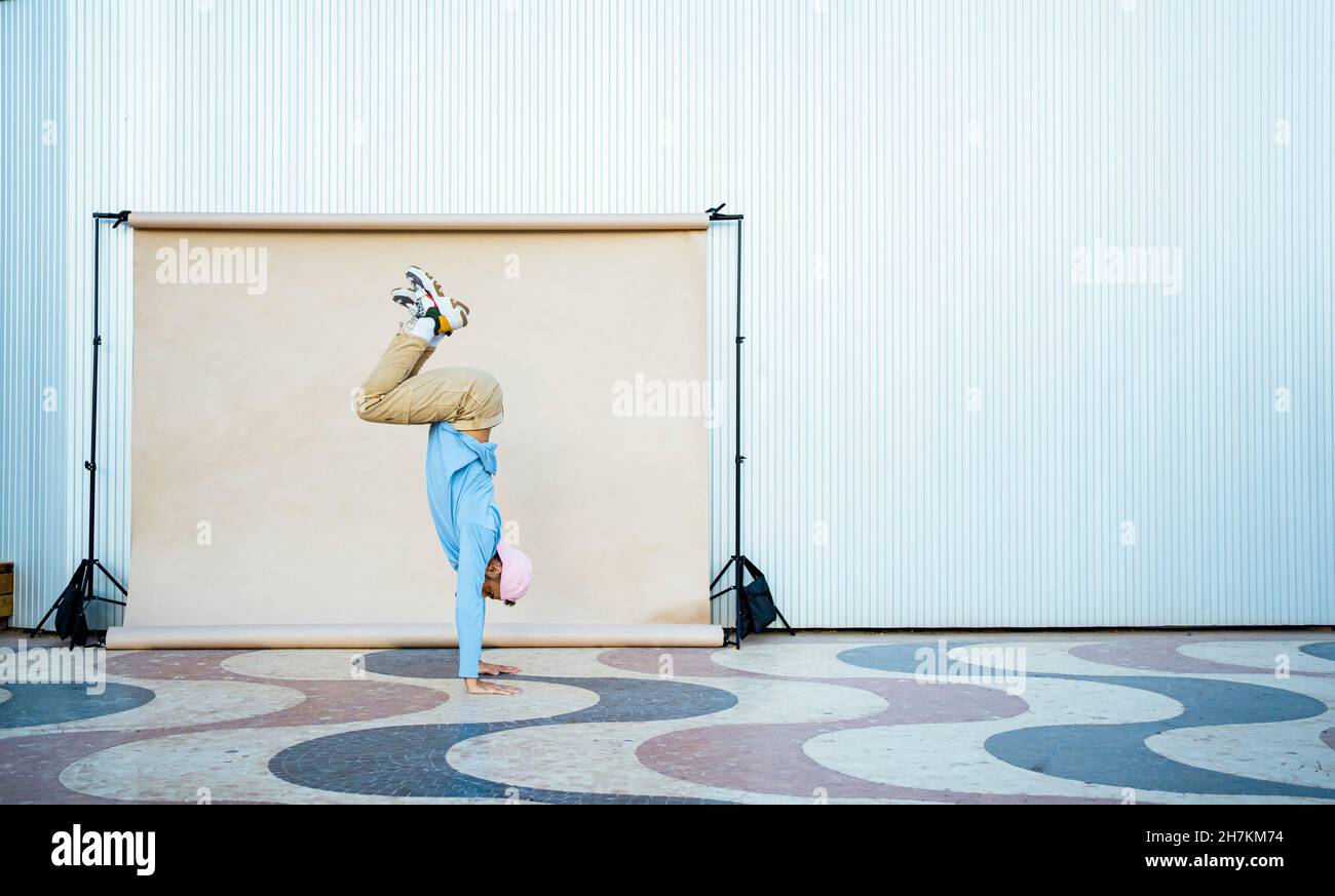 Mid adult man performing handstand on floor by backdrop Stock Photo - Alamy