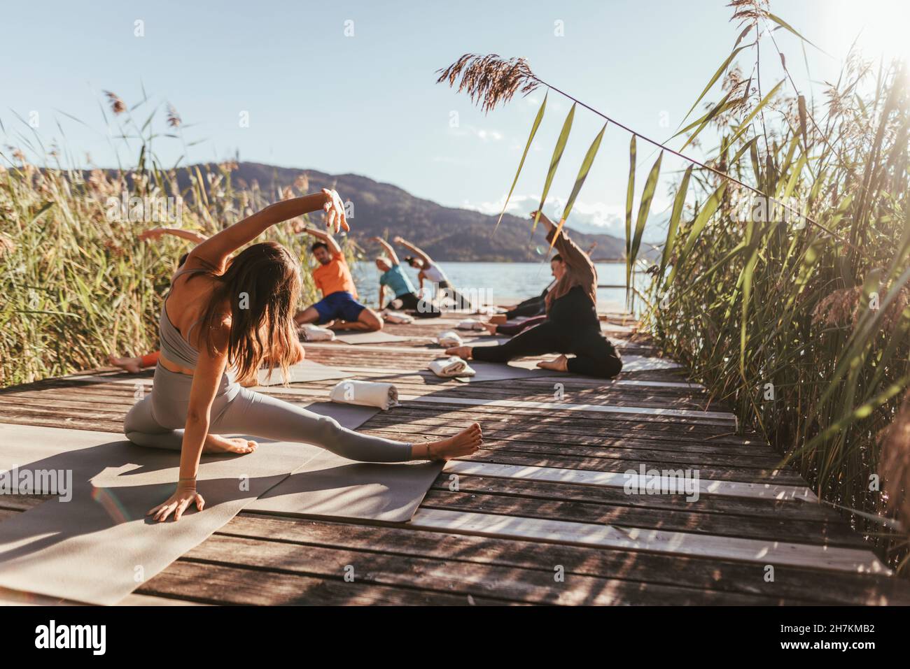 Female instructor teaching stretching exercise during yoga class Stock ...