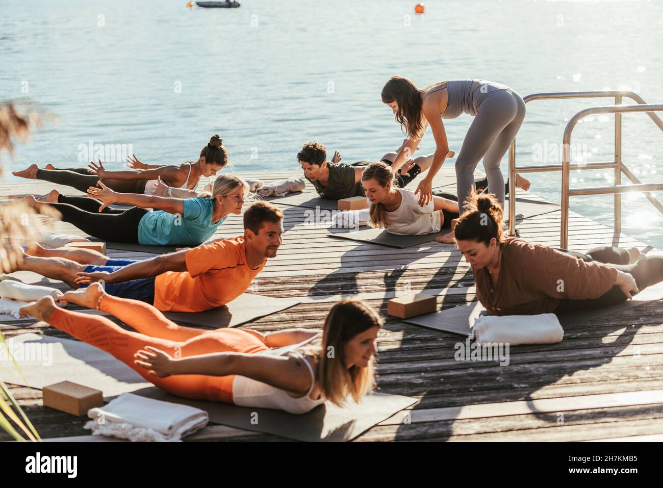 Female instructor guiding woman doing yoga during class Stock Photo - Alamy