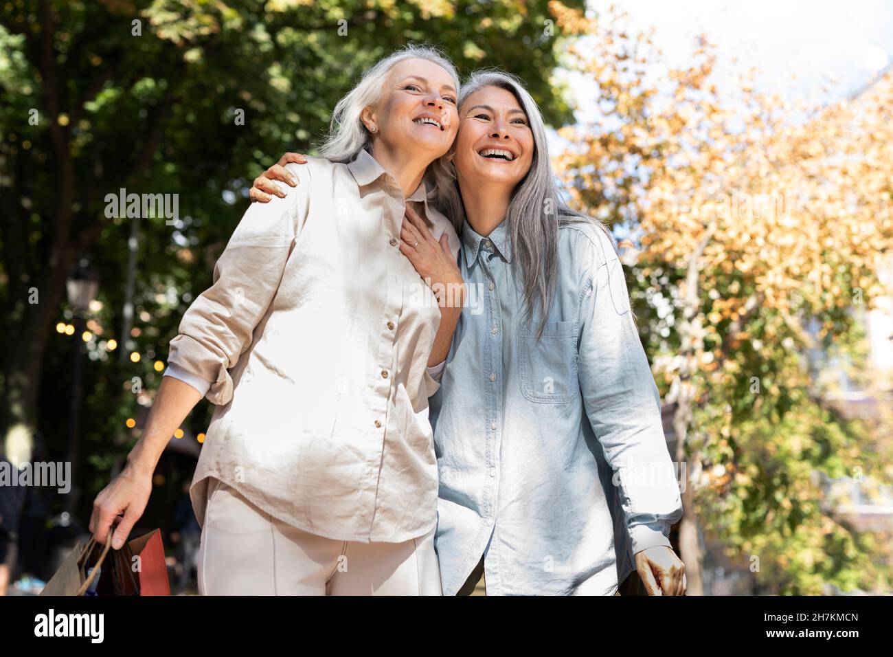 Female friends laughing while standing together Stock Photo - Alamy